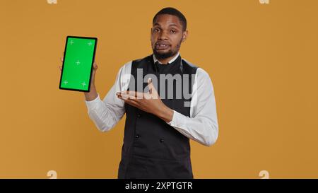 Restaurant waiter presenting a green screen layout on tablet against ...