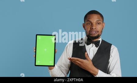 Bellman hotelier showing a tablet with green screen display in studio ...