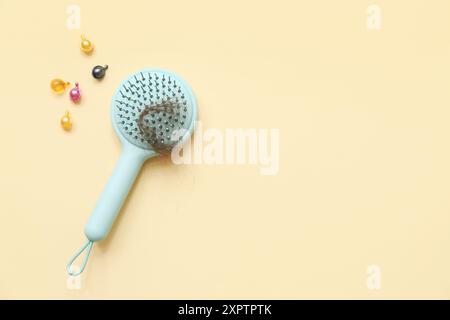Brush, capsules and hair clump on beige background Stock Photo - Alamy