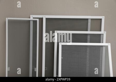Set of window screens near beige wall indoors Stock Photo - Alamy