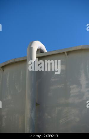 Pale green large scale water storage tank against a deep blue sk Stock ...