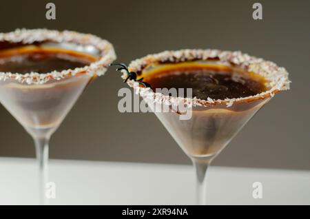 Two martinis with black spider decorations on top. The martinis are in ...