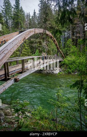 Hikers crossing the bridge over the Middle Fork Snoqualmie River at the ...