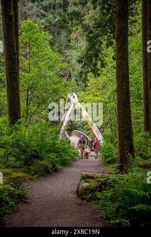 Hikers crossing the bridge over the Middle Fork Snoqualmie River at the ...