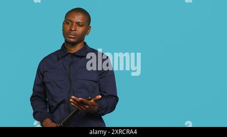 Portrait of security guard menacingly smacking hand with baton while ...