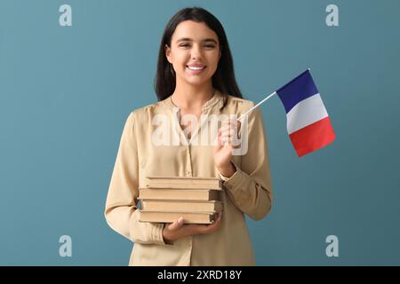 Female French language teacher with books and flag on blue background ...
