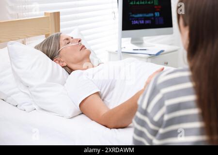 Coma patient. Woman near her unconscious mother in hospital Stock Photo ...
