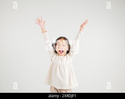 A jubilant kid girl raises her fists in celebration of her success ...