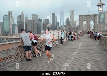 A person jogs across the Brooklyn Bridge as it snows on Sunday, Jan. 25 ...