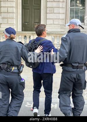 A man is detained by police as people take part in a Save Our Future ...