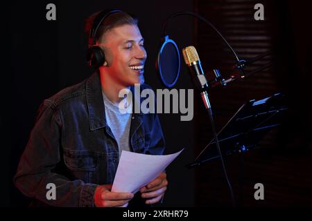 Singer with sheet recording song in professional studio Stock Photo - Alamy