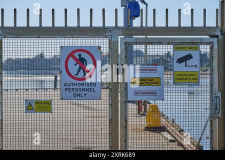 Gate entrance to a private marina dock with fishing boats, with signs ...