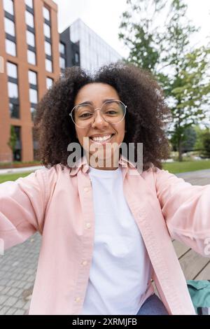 Image of joyful woman taking selfie photo on cellphone and gesturing ...