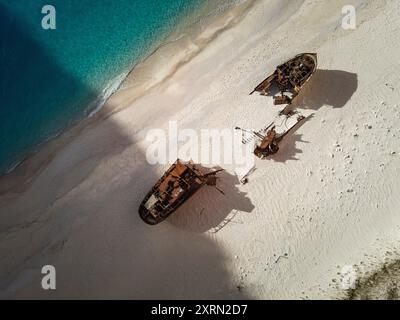 Aerial view of a beach with two shipwrecks on the sandy shore and clear ...
