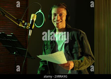 Singer with sheet recording song in professional studio Stock Photo - Alamy