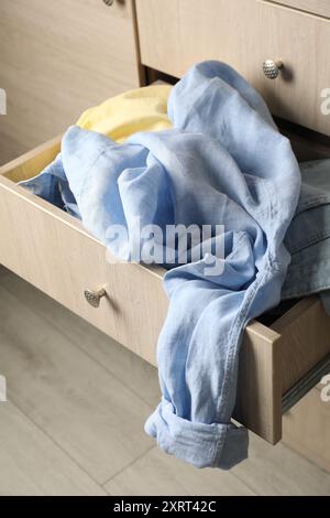 Cluttered wooden wardrobe with disorganized clothing - a concept of ...