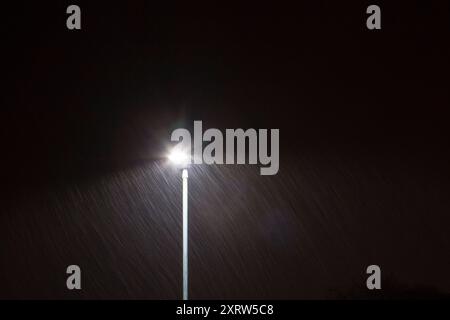 Snow falling through the light of a street lamp Stock Photo - Alamy