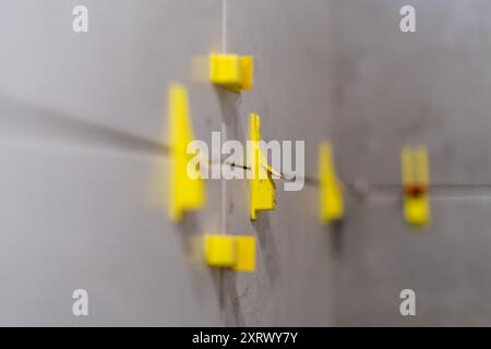 Plastic clips and wedges securing tiles in place for perfect alignment ...