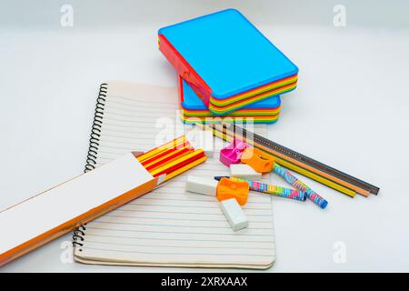 a stack of pencils, pens, and pencils are on a notebook with color book ...