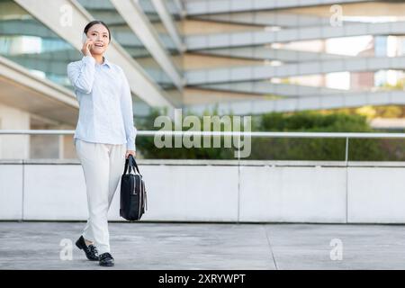 Asian woman professional talking smartphone voice message remote work ...