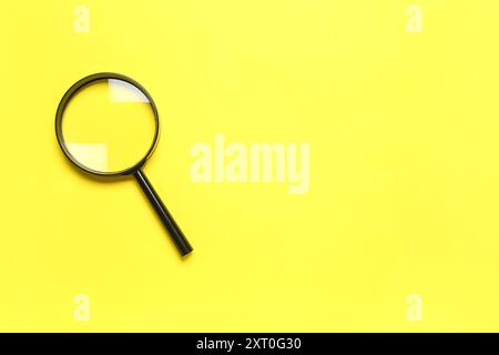 Black magnifiers on yellow background Stock Photo - Alamy