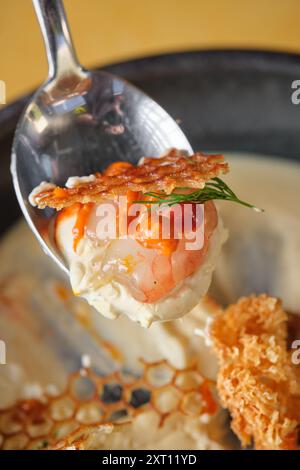 Portion of crispy potato topped fish pie on a black plate isolated on a ...