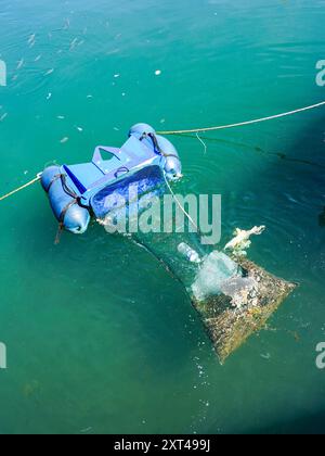 Automated garbage collection device with a net bag in the water of the ...