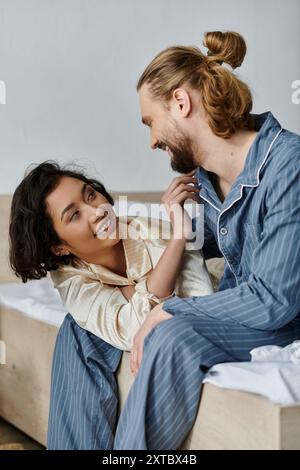 A loving couple in pajamas enjoys a quiet morning together, snuggling ...