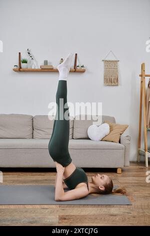 Beautiful woman practices inversion yoga asana Halasana - Plow pose in ...