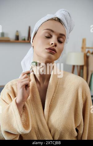 Young woman in robe uses face roller during morning routine Stock Photo ...