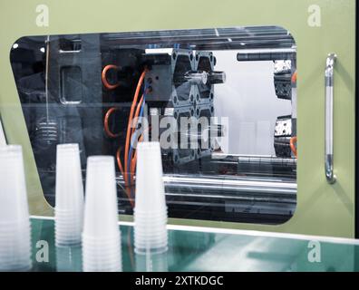 Plastic cups from plastic injection molding press machine. Industrial ...
