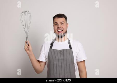 Emotional pastry chef with big whisk on light grey background Stock ...