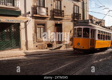 The classic 28 yellow tram in the historic district of Lisbon in ...