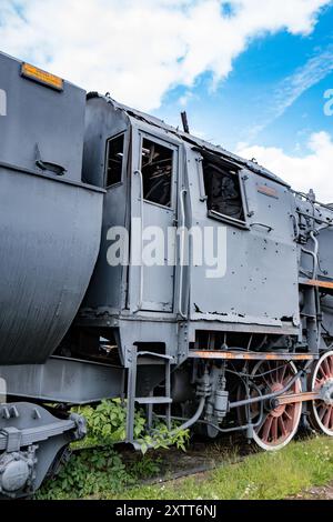 Detailed view of an old rusty steam train's wheel assembly in an ...
