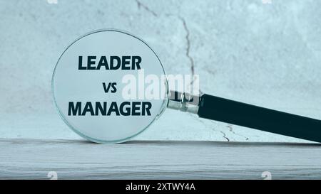 Leader vs manager is shown through a magnifying glass on a gray ...
