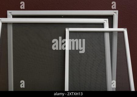 Set of window screens near brown wall, closeup Stock Photo - Alamy