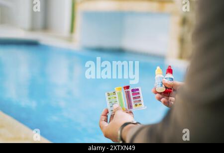 Tester kit to measure chlorine and ph in swimming pools. Person testing ...