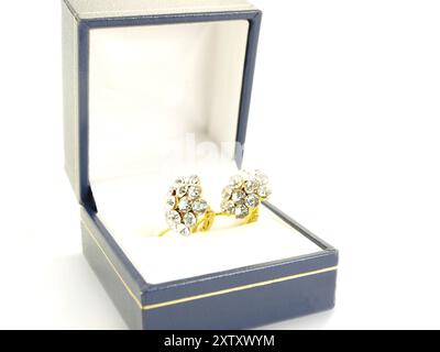 Golden earrings in white gift box on wooden background Stock Photo - Alamy