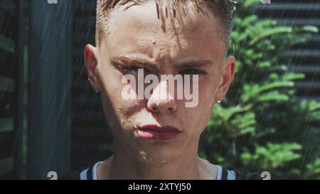 Cinematic shot of serious teenager looking at camera while standing ...