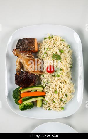 Grilled meat, white rice and vegetables on wooden table Stock Photo - Alamy
