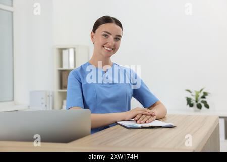 Professional receptionist working at wooden desk in office Stock Photo ...