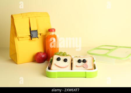 Bag, sandwiches with smiley faces in lunch box and bottle of juice a on ...