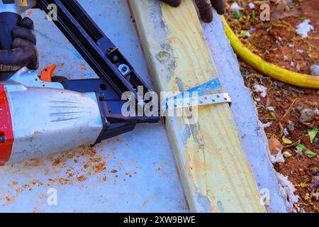 Nailing wooden beams to concrete with an air pneumatic hammer during ...