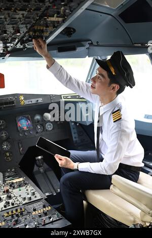 Pilot use digital tablet in passenger airplane jet Stock Photo - Alamy