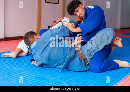 Judo fighters fighting in dojo with big windows at background Stock ...
