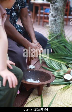 Scraping fresh coconut, traditional food demonstration, Fiji Stock ...