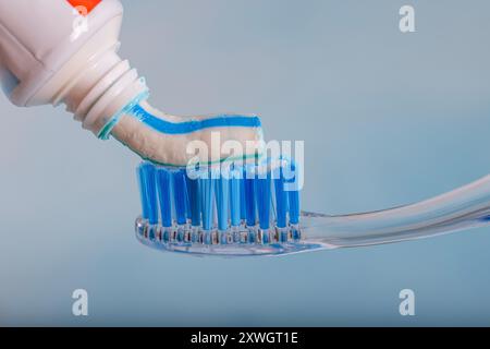 Applying toothpaste on brush against blurred background, closeup Stock ...