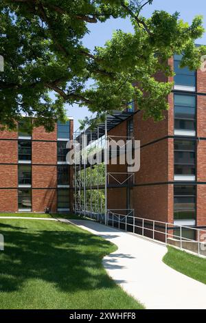 modern multi-storied walkway connection between two red brick buildings ...