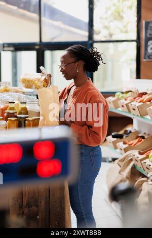 Woman Filling Paper Bag With Pasta From Dispenser In Plastic Free Food ...