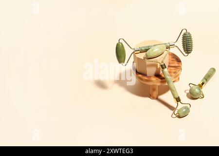 Facial massage tools and plaster stands on beige background, closeup ...